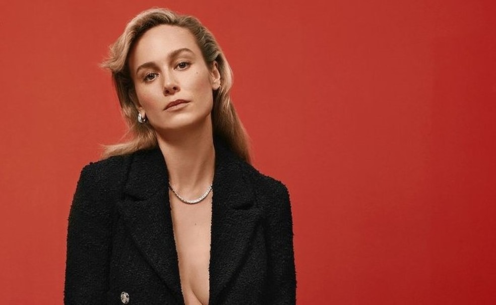 Brie Larson posa sem maquiagem com vestido vermelho e surpreende fãs