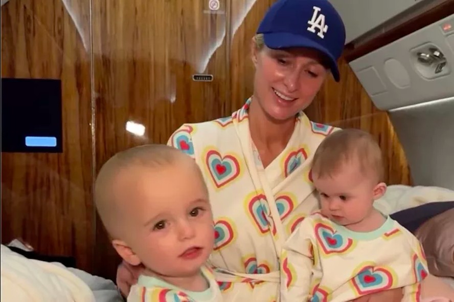 Paris Hilton posa de pijama combinadinho com os filhos em cama de jatinho